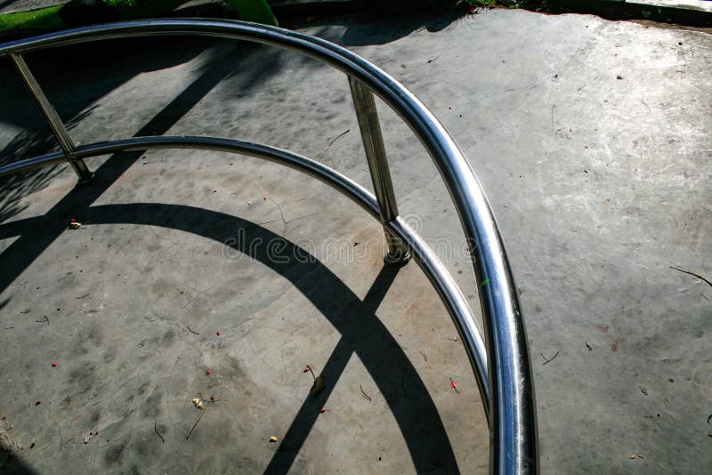 Curved Stainless Steel Railing Casting Shadow on Textured Concrete ...