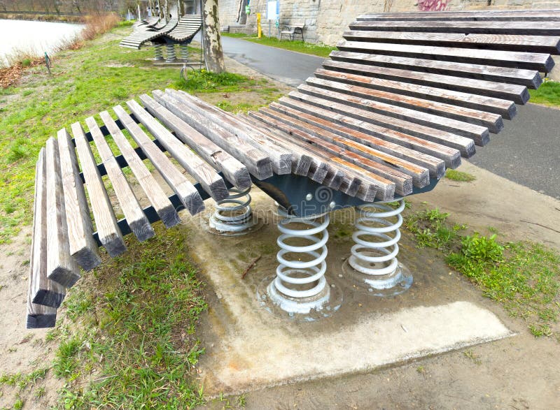 Curved Wooden Benches with Metal Springs in Park Setting Editorial ...