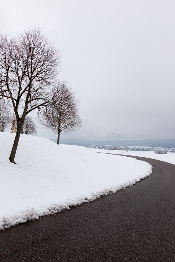 A Curvy Road in the Midst of Snow, with Trees at the Side Stock Photo ...