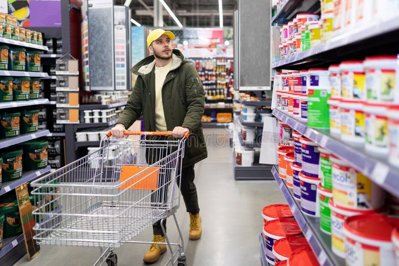 A Customer with a Basket on Wheels Strolls through the Hardware Store ...