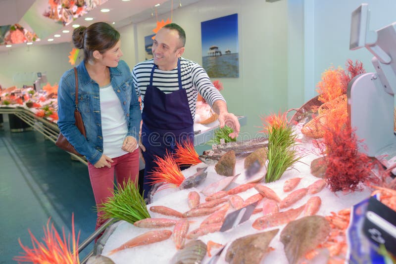 Customer buying fresh fish stock photo. Image of vendor - 265994800