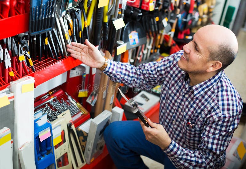Close Up. Salesman Is Showing Bearded Client New Winches In Power Tools ...