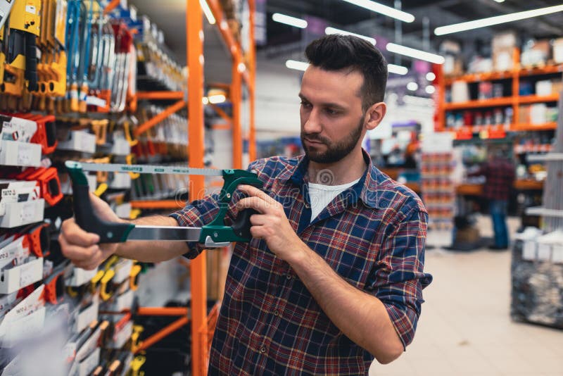 A Customer in a Hardware Store Chooses a Hacksaw for Metal Stock Photo ...