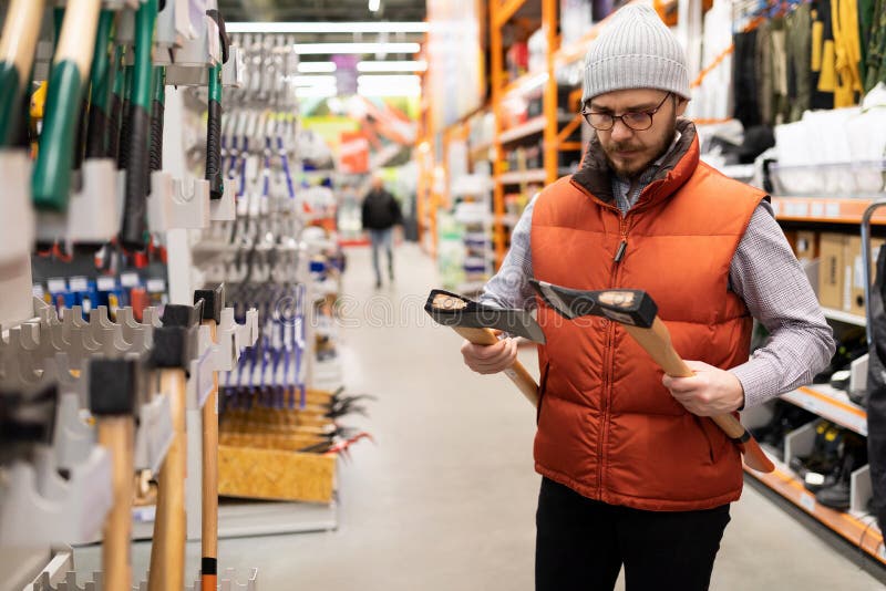 A Customer in a Hardware Store Compares Two Axes Stock Photo - Image of ...