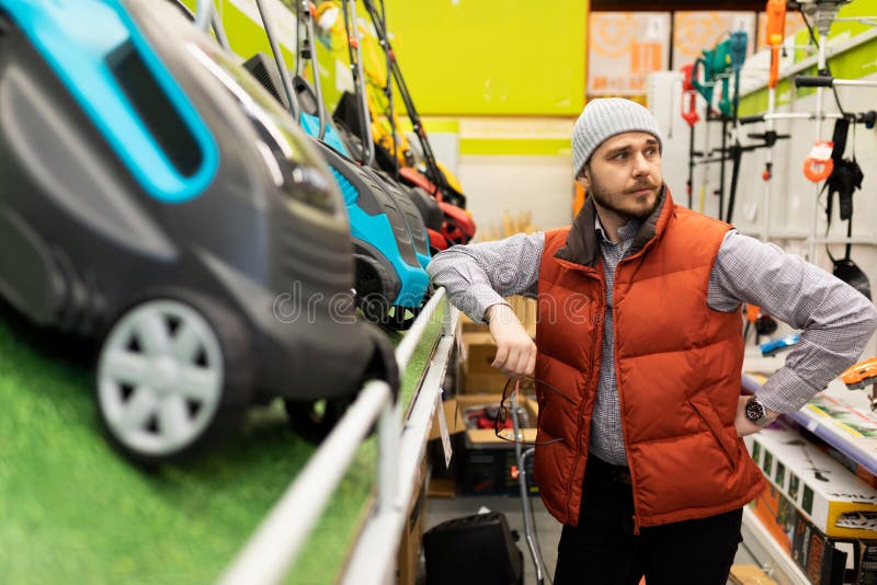 A Customer in a Hardware Store is Determined between a Petrol and an ...