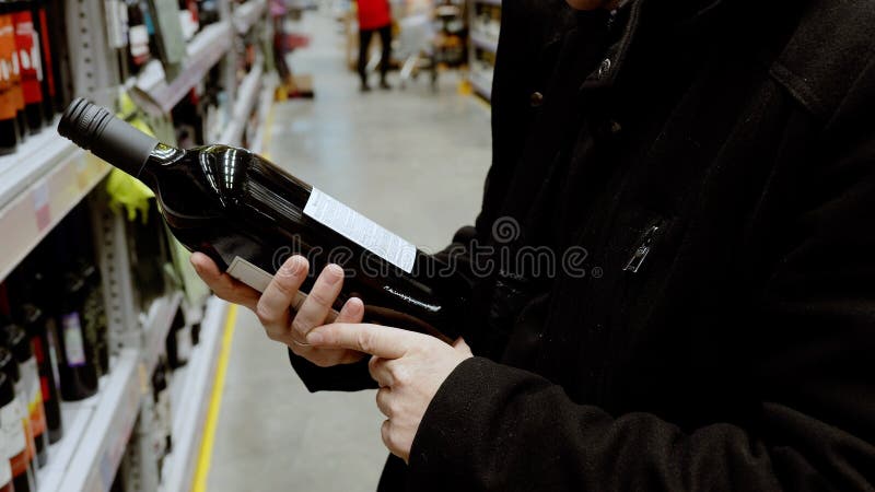 Wine Enthusiast Carefully Examining Bottle Label while Browsing ...