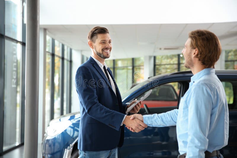 Salesman Shaking Hands with Customer while Giving Car Key in Auto ... Salesman Shaking Hands with Customer while Giving Car Key in Auto ...
