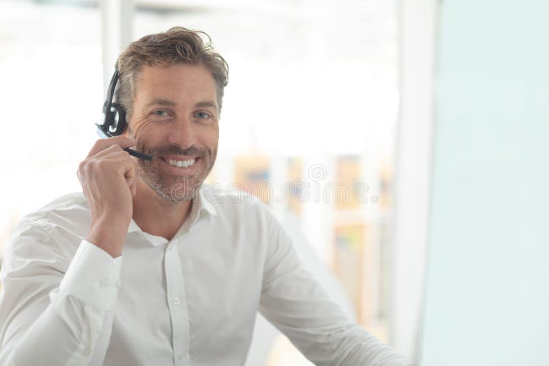 Customer Service Executive Talking on Headset at Desk in a Modern ...