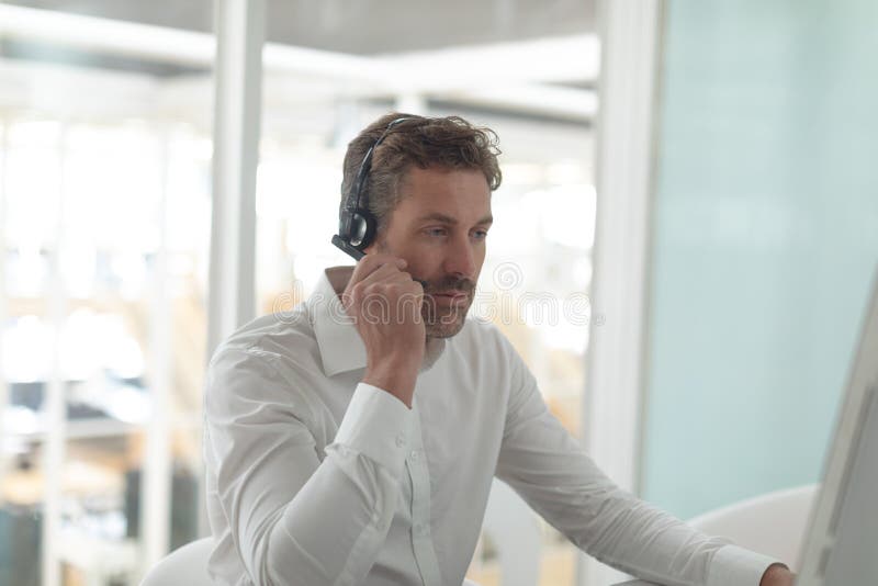 Customer Service Executive Talking on Headset at Desk in a Modern ...