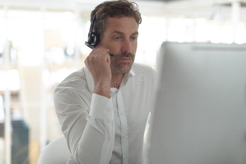 Customer Service Executive Talking on Headset at Desk in a Modern ...