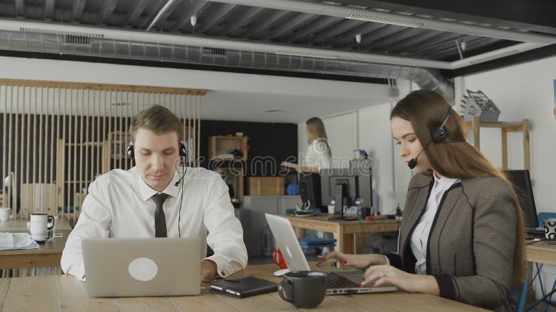 Customer Service Woman and Man Operators Taking Calls in Busy Call ...