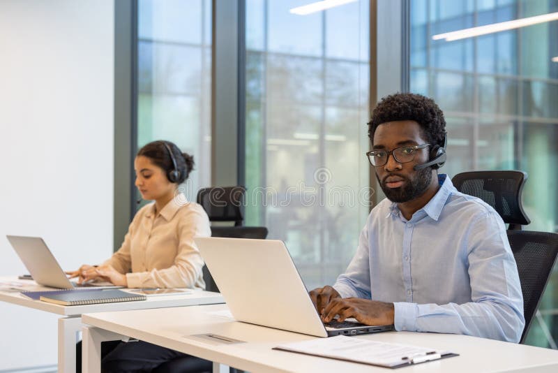 Customer Service Professionals Working with Headsets on Laptops in ...