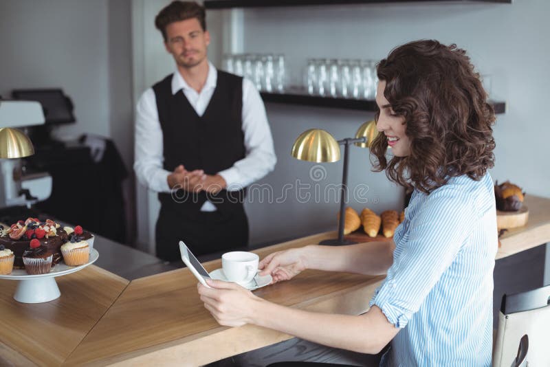 Customer Using Digital Tablet while Having Coffee at Counter Stock ...