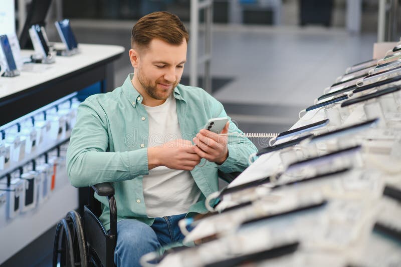 Customer in Wheelchair Using Smartphone in Electronics Store Stock ...