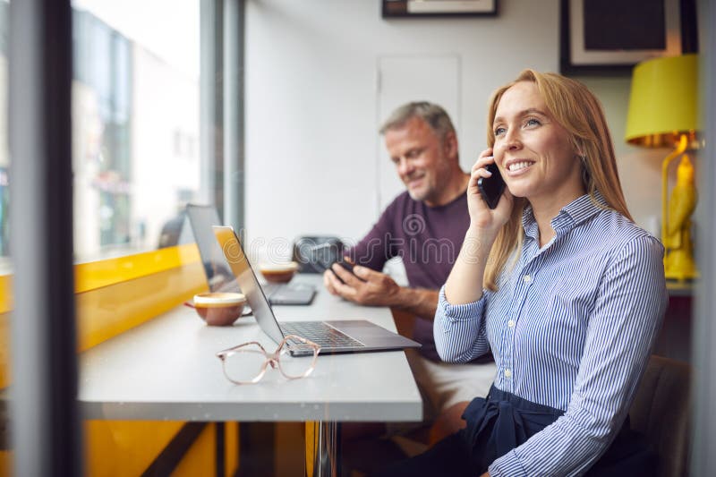 Customers in Coffee Shop Window Working on Laptops and Making Call on ...