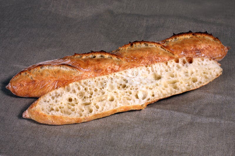 Cut Across the Long White Bread Lies on a Grey Linen Tablecloth Stock ...