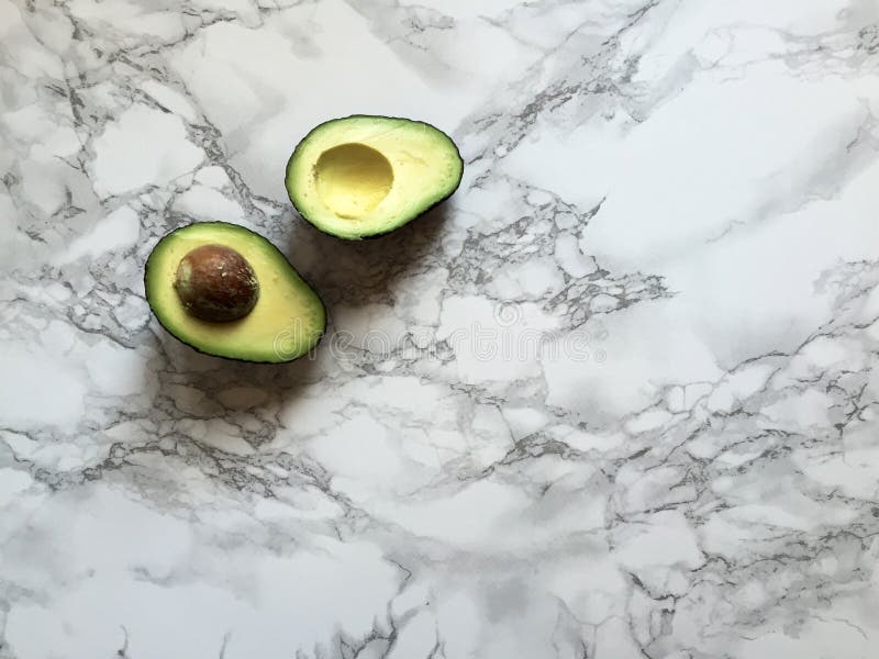 Cut Avocado Halves with Pit on Marble Countertop with Copy Space Stock ...