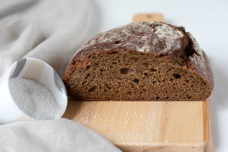 Cut Black Rye Bread with Salt on a Wooden Board on a Light Background ...