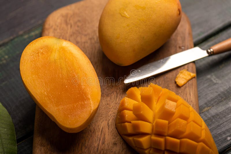 Cut and Complete Mangoes on the Chopping Board Stock Photo - Image of ...