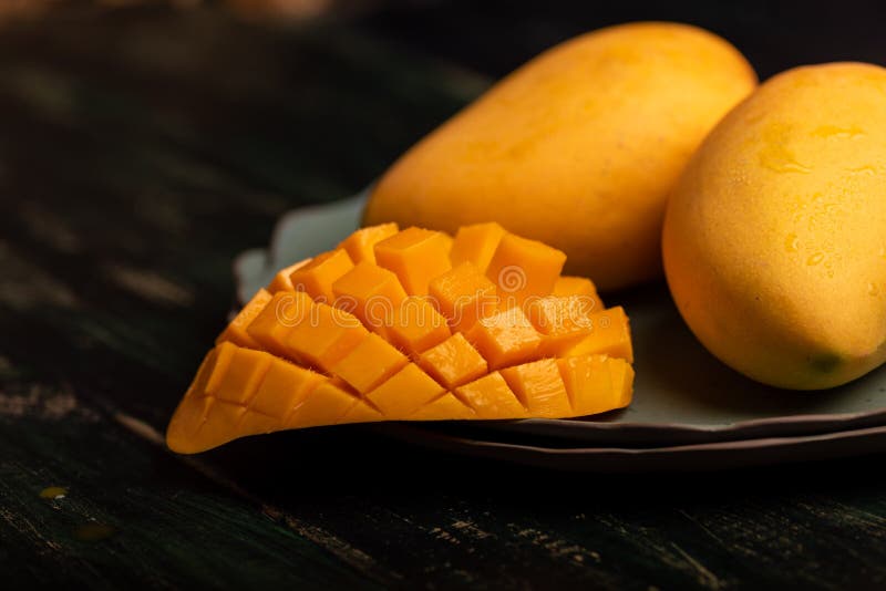 Cut and Complete Mangoes on a Plate in a Dark Environment Stock Image ...