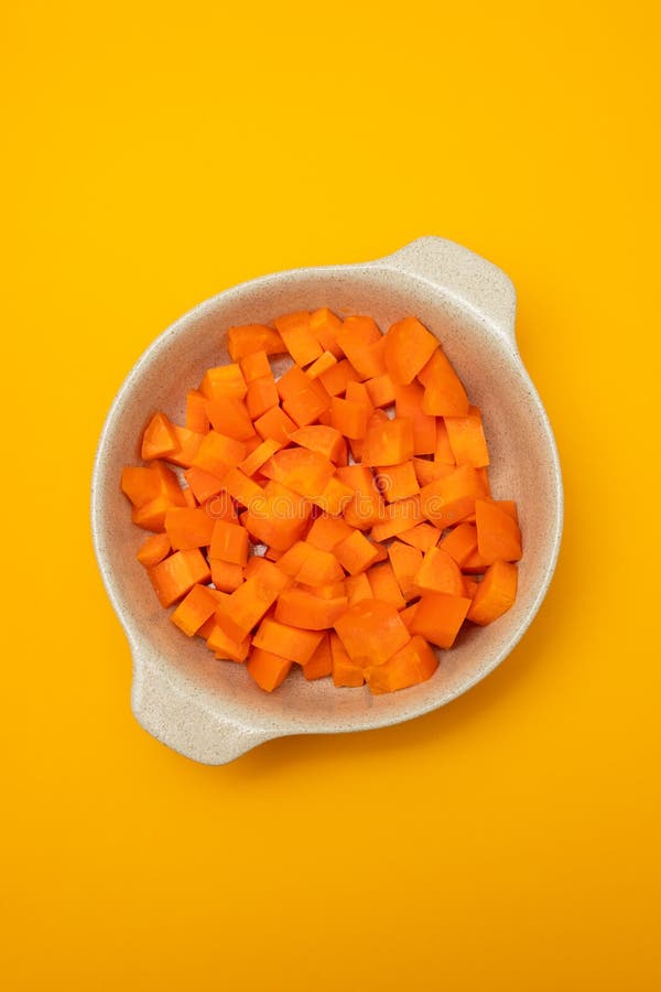 Cut Cubes of Fresh Carrot in the Bowl on Yellow Stock Photo - Image of ...