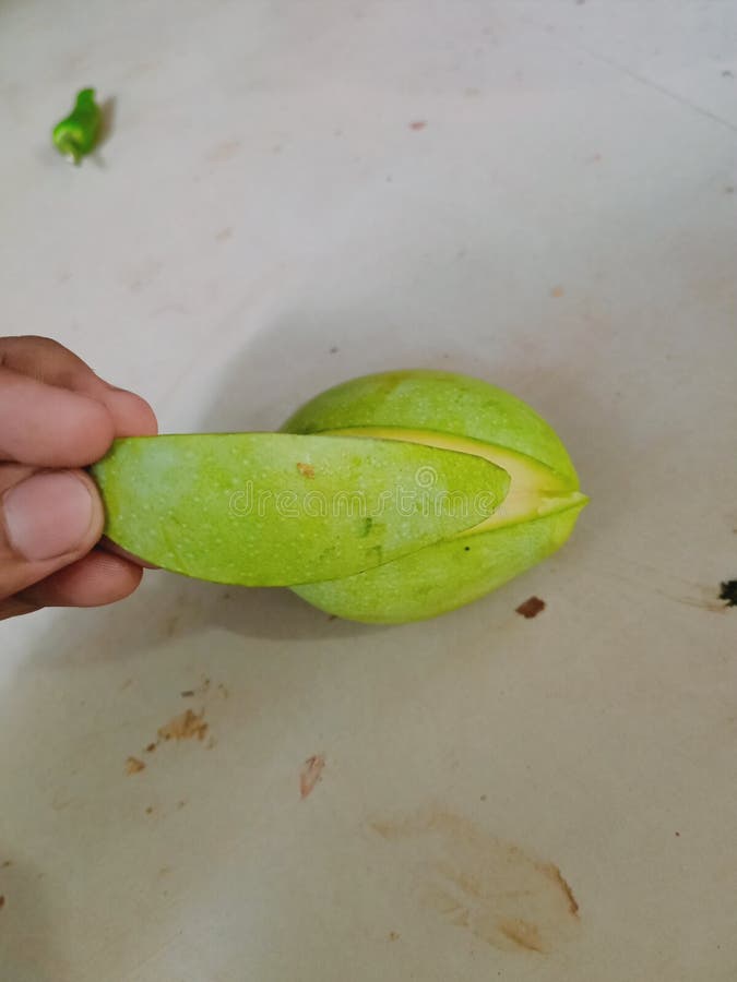 Cut of green mango stock image. Image of cuisine, hand - 179842023