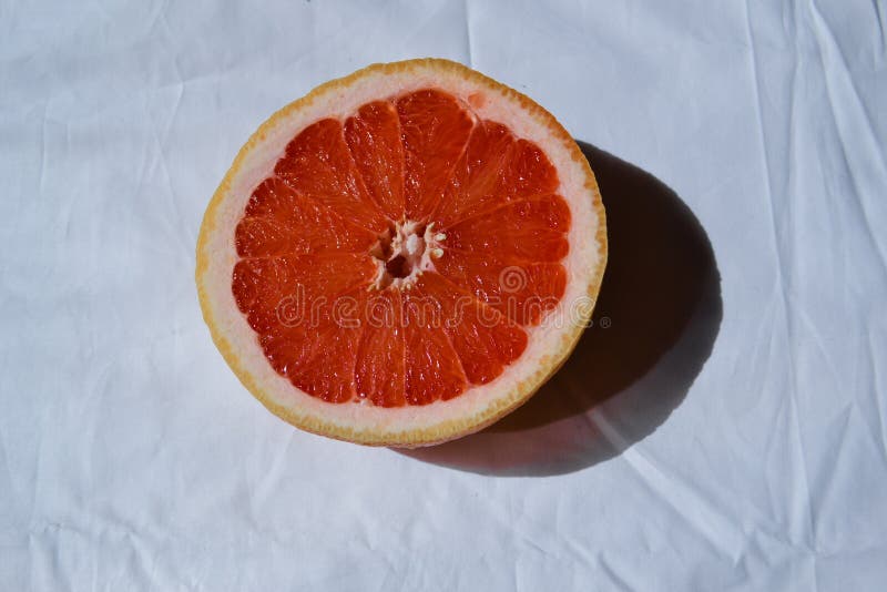 Cut Half Bright Red Orange Half Grapefruit on White Fabric with Folds ...