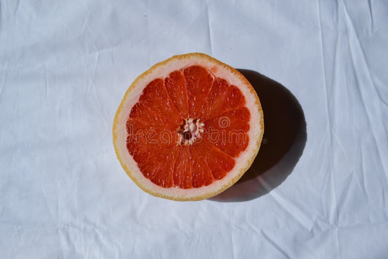 Cut Half Bright Red Orange Half Grapefruit on White Drapery with Folds ...