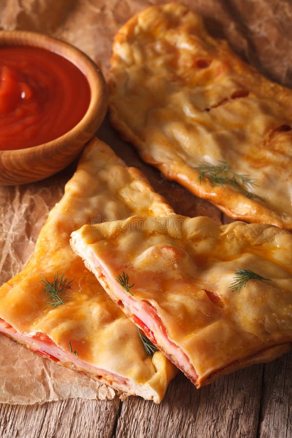 Cut Italian Pizza Calzone with Ham and Cheese Close-up. Vertical Stock ...