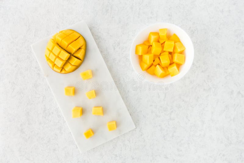 Cut Mango Half and Mango Cubes on Marble Cutting Board Stock Photo ...