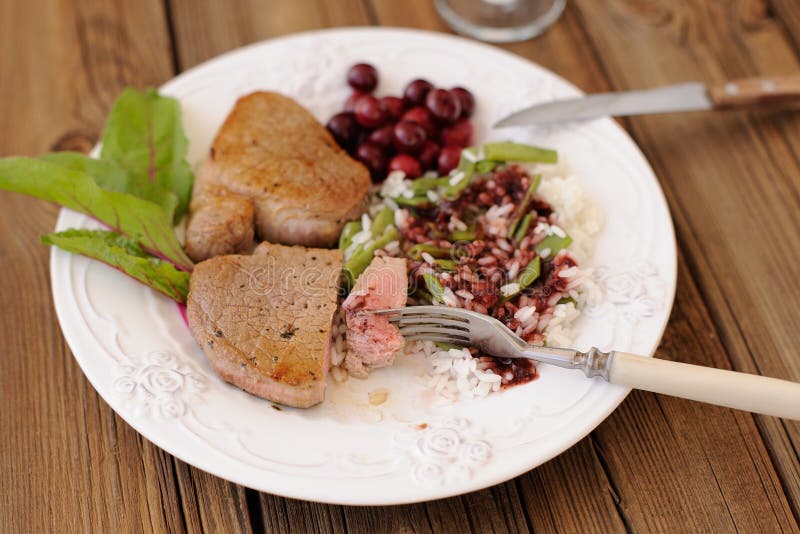 Cut Medium Rare Steak with Rice, Berry Sauce and Chard Stock Image ...