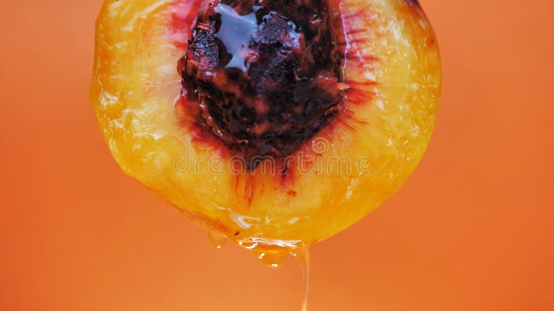 Cut Peach with Juice Dripping on an Orange Background Stock Photo ...