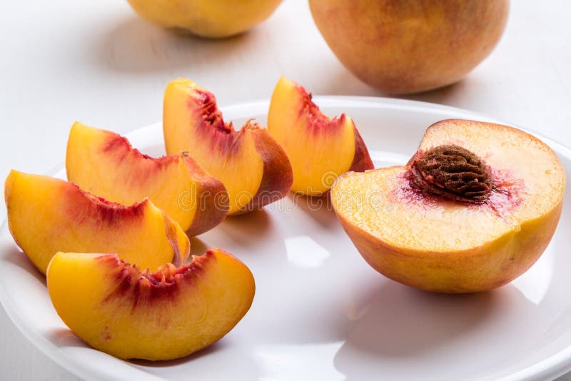 Cut peach on white plate stock photo. Image of fresh - 77718462