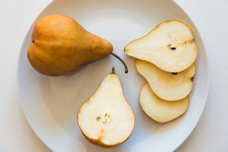 Cut pears on a white plate stock photo. Image of vegan - 170584690