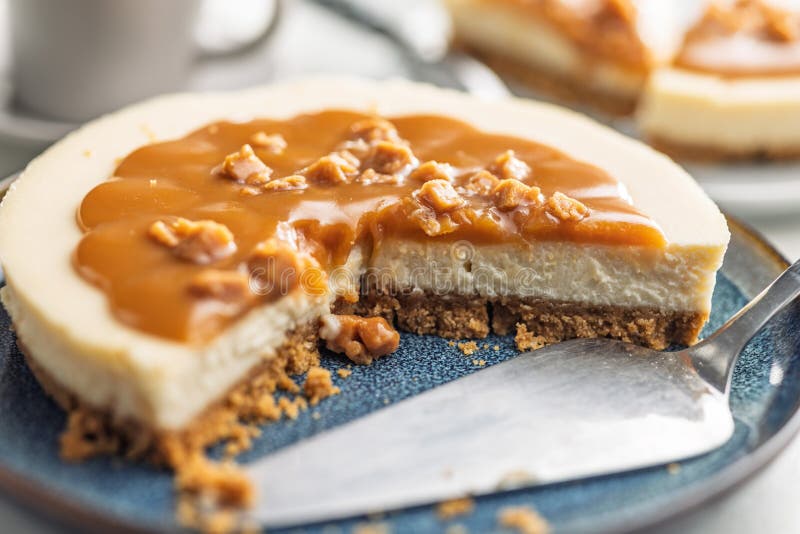 A Cut Piece of Cheesecake with Caramel Topping on Plate on Kitchen ...