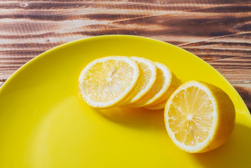 Cut into Round Slices of Sour Yellow Lemon on a Yellow Plate ...