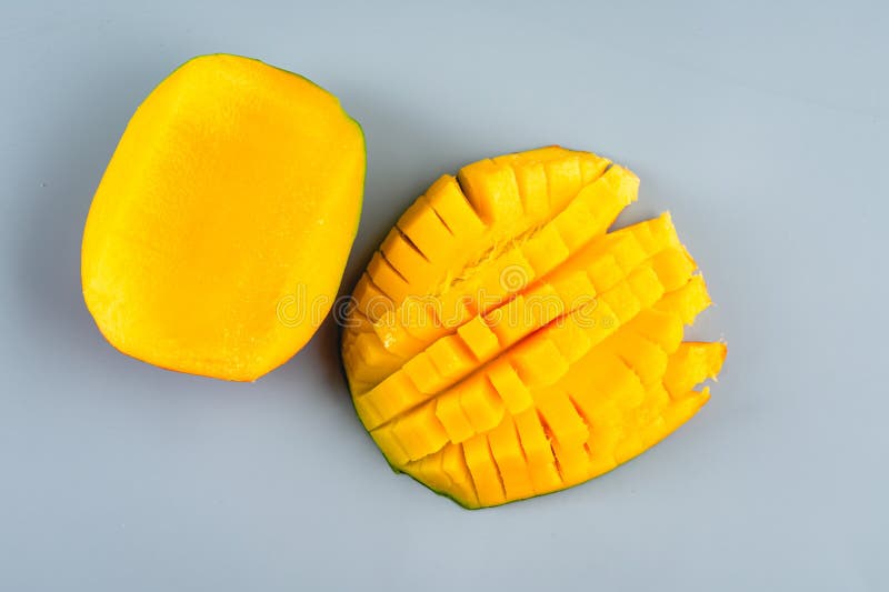 Cut and Uncut Cored Mango Halves on a Blue Background Stock Image ...