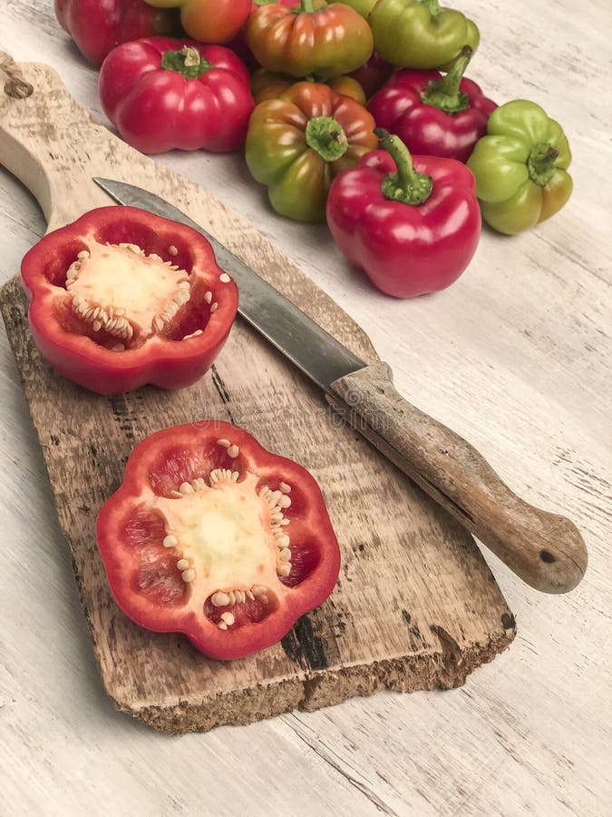 Cut and Whole Bell Peppers on a Cutting Board on a Wooden Table Stock ...