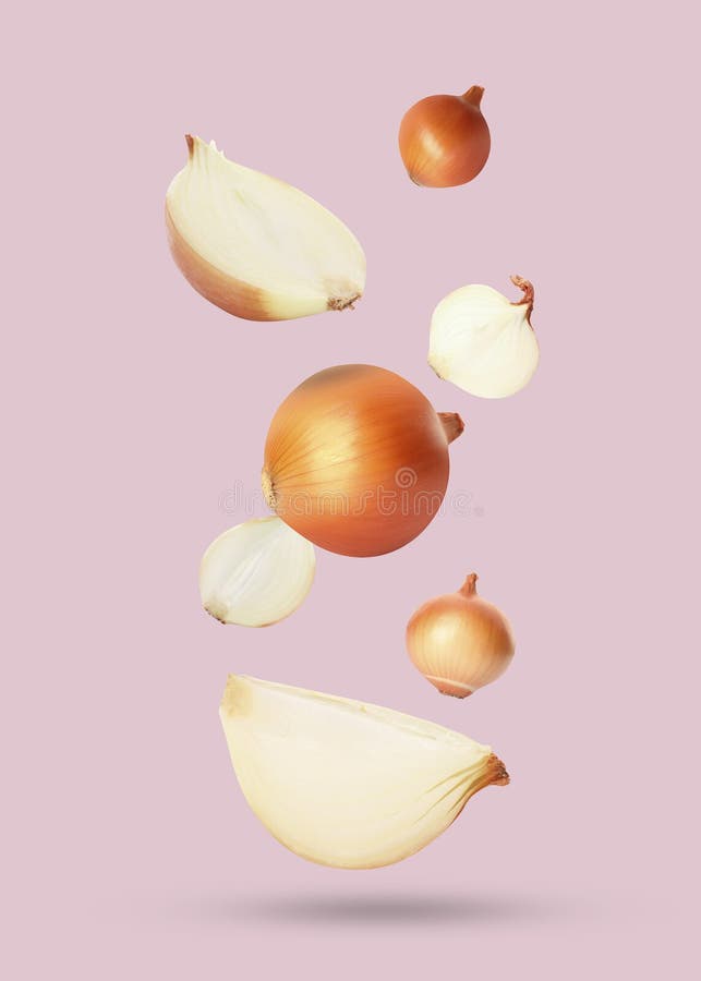 Cut and Whole Onions Falling on Pastel Pink Background Stock Photo ...
