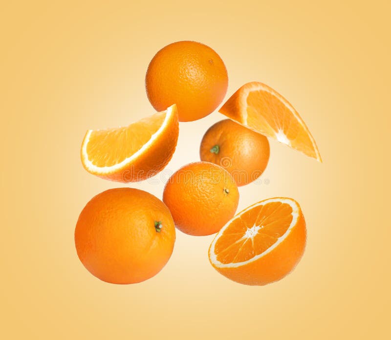 Cut and Whole Oranges Flying on Pale Orange Background Stock ...