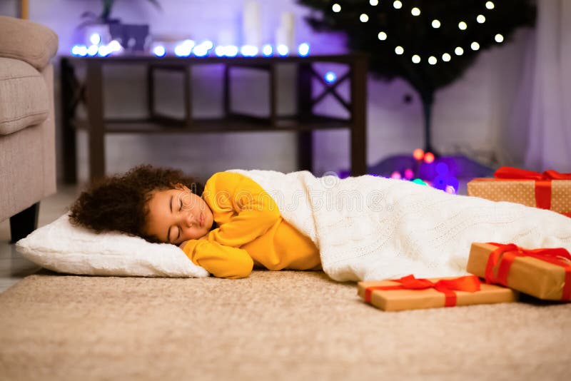Cute African Kid Sleeping Near Christmas Tree on Floor at Home Stock ...