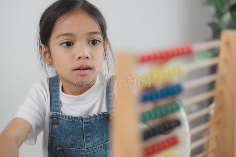 Cute Asian Child Girl Learning To Count Using an Abacus in the ...