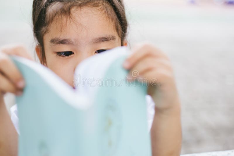 Cute Asian Girl Reading a Book in School Stock Image - Image of ...