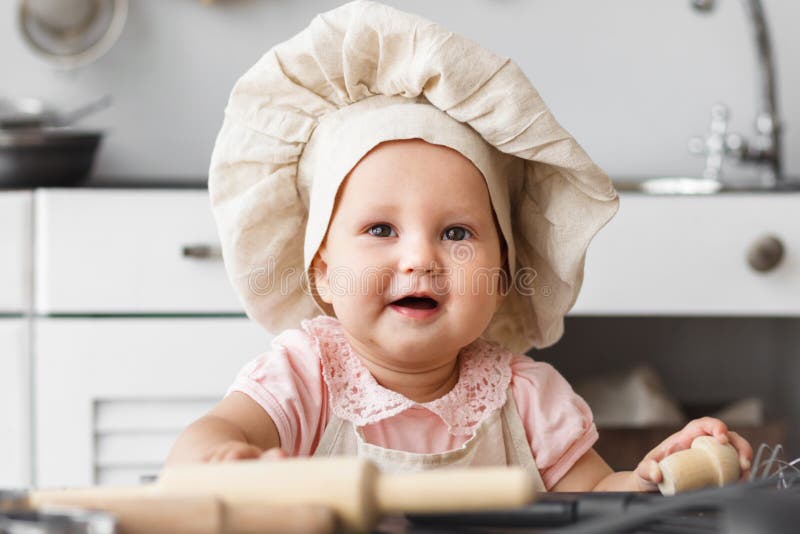Cute Baby Cook with Wooden Tools in a Cap and an Apron Making Cookies ...