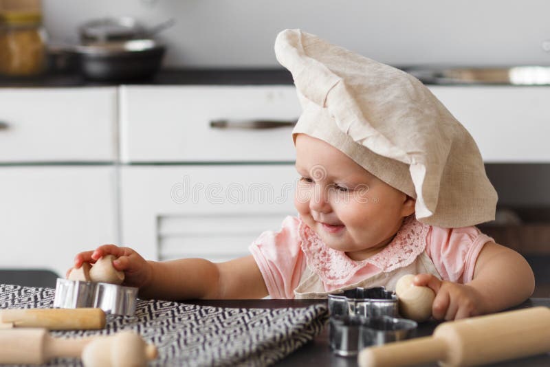 Cute Baby Cook with Wooden Tools in a Cap and an Apron Making Cookies ...