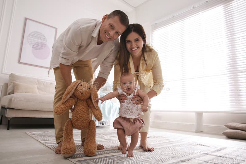 Cute Little Baby Doing First Steps with Parents` Help at Home Stock ...