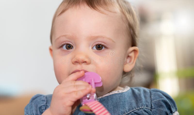 Cute Baby Girl Biting a Plastic Clip Stock Photo - Image of cute ...