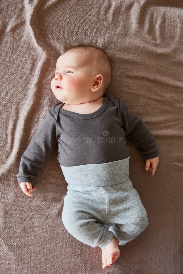 Cute Baby Lies Relaxed on His Back Stock Photo - Image of room, living ...