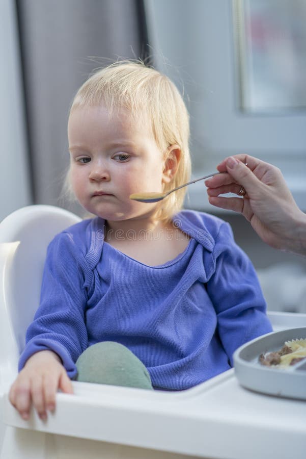 Cute Baby Refuses To Eat when Mom Feeds Her with a Spoon in the Kitchen ...