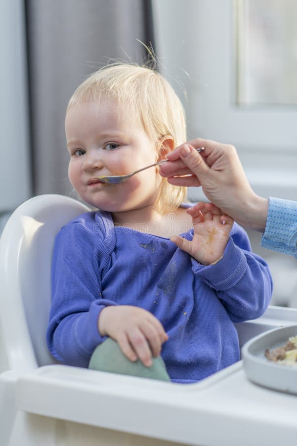 Cute Baby Refuses To Eat when Mom Feeds Her with a Spoon in the Kitchen ...